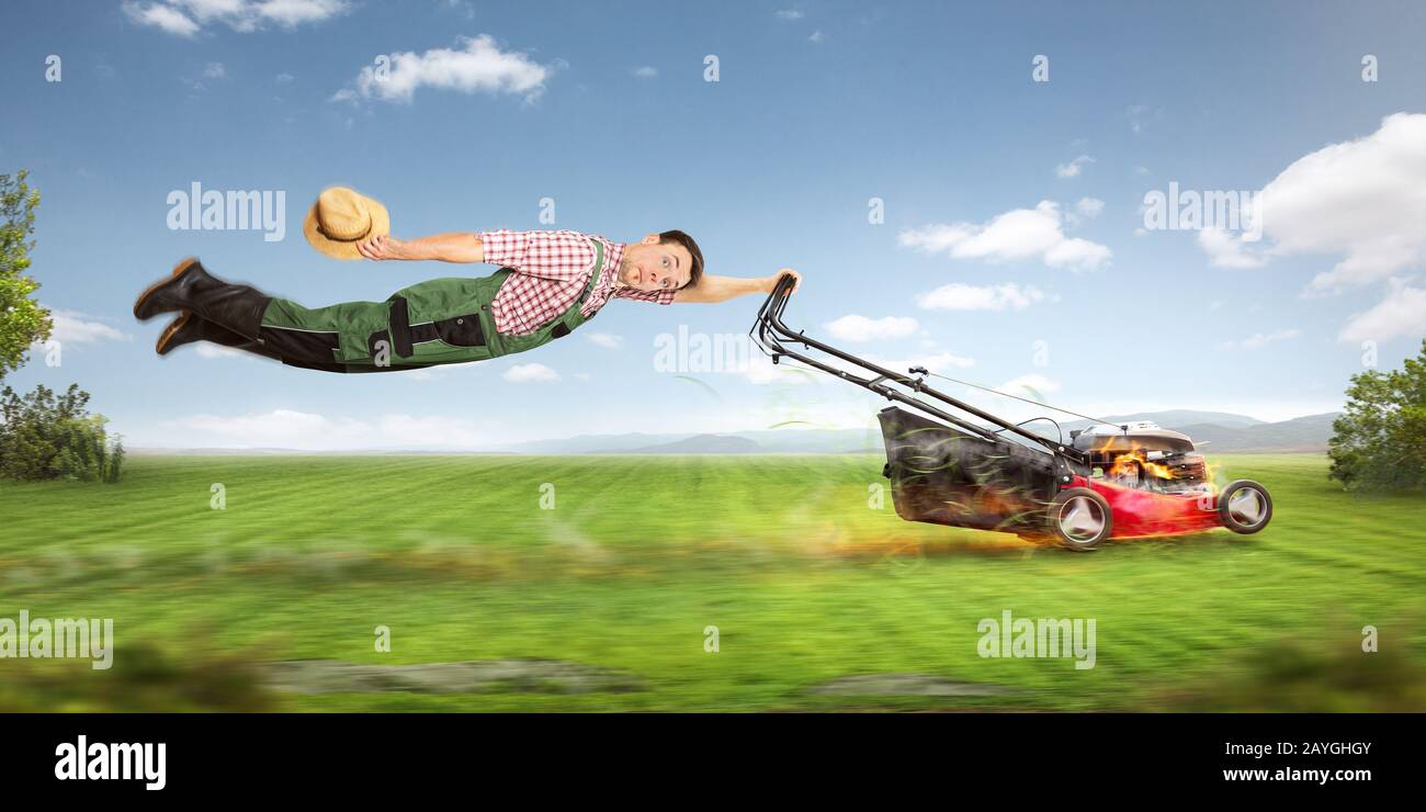 Funny gardener being pulled across the lawn by a lawn mower Stock Photo ...