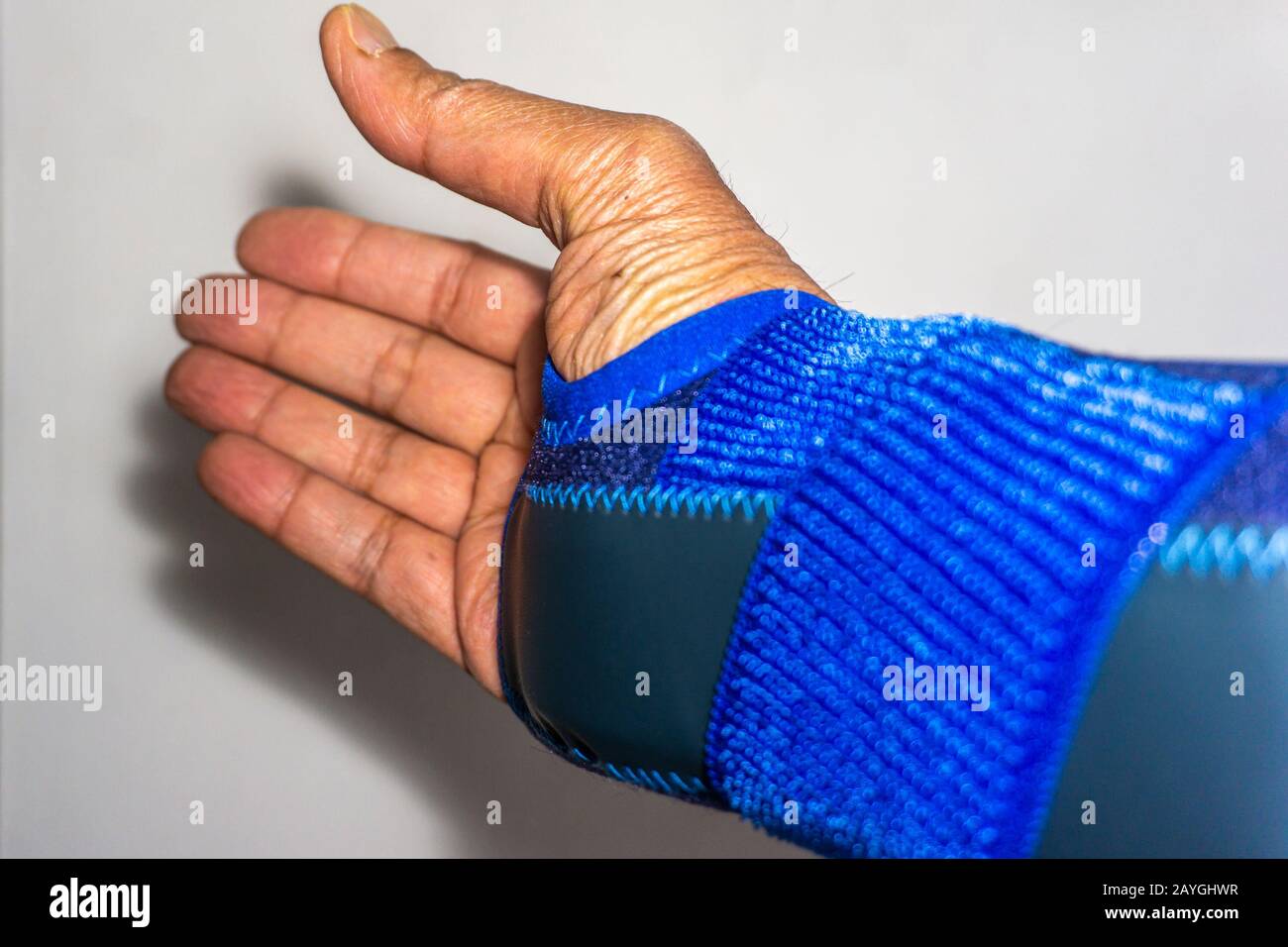 Blue hand strap on injured hand or twisted wrist Stock Photo - Alamy