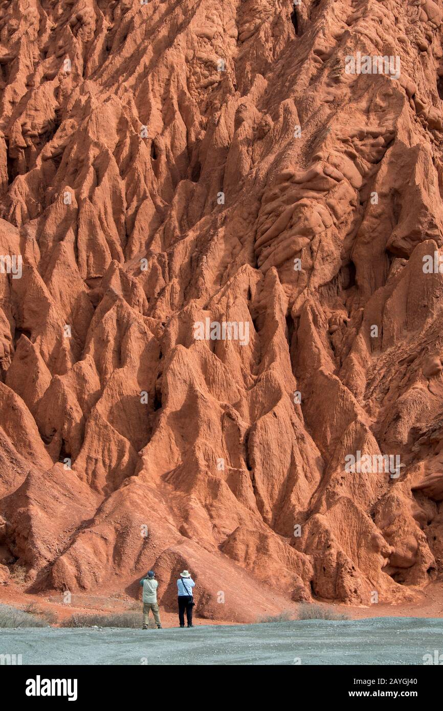 People in front of a colorful rock formations created by erosion in the ...