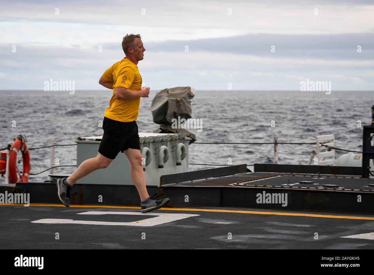 A Royal Canadian Navy sailor jogs on the flight deck of HMCS VILLE DE ...