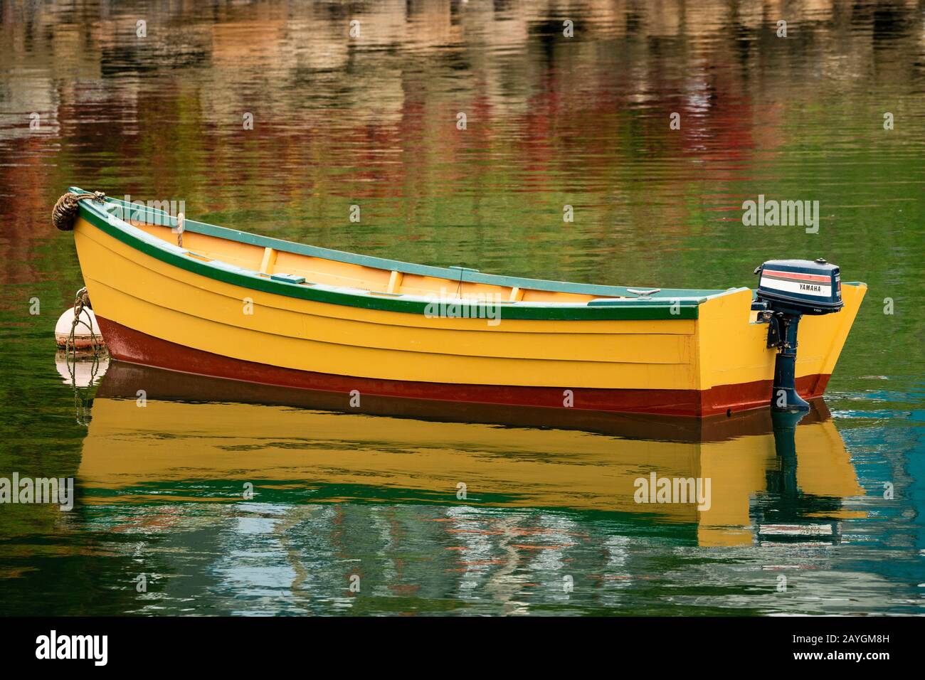 Moored traditional motorboat reflecting on the water along the ...