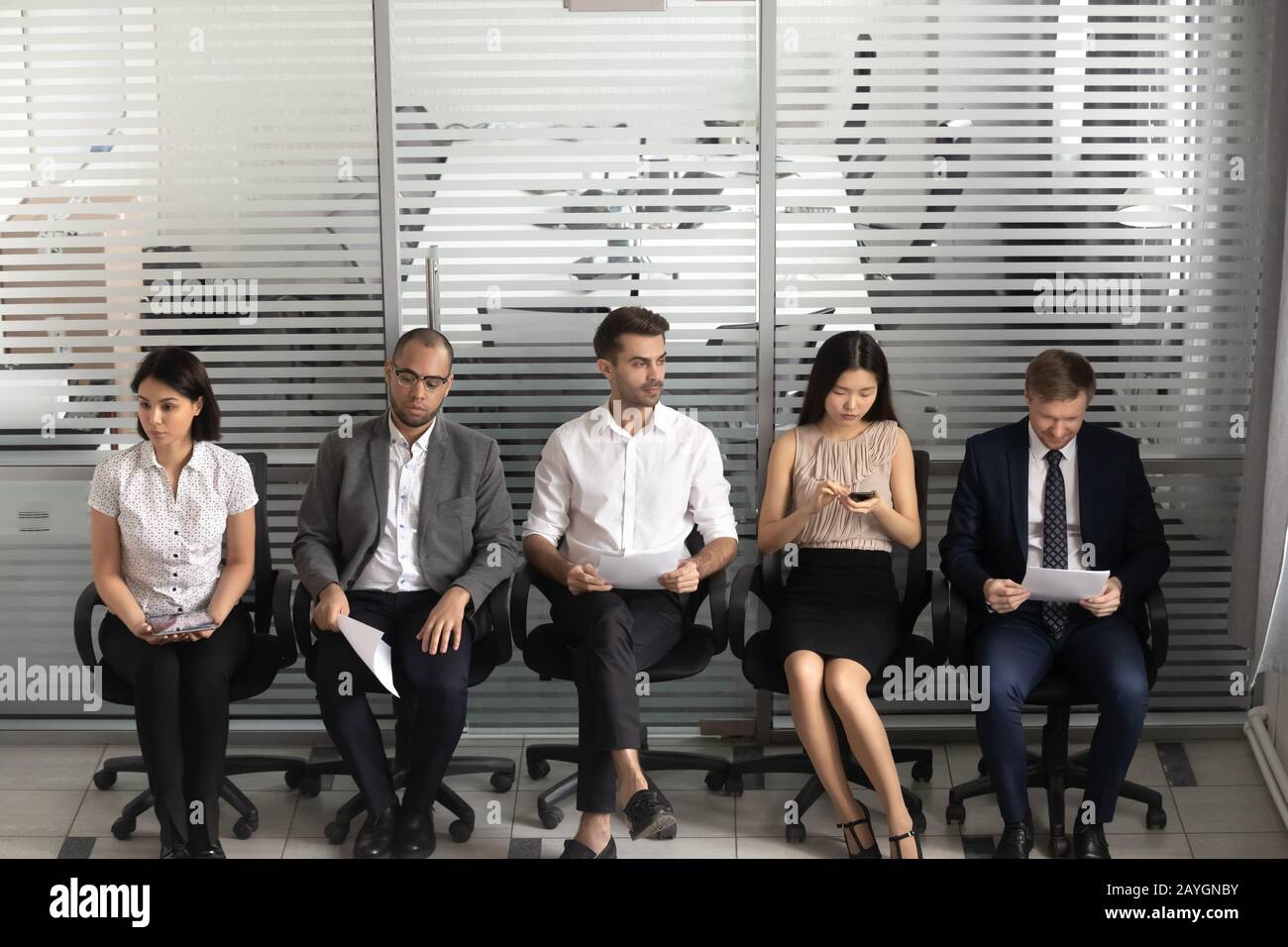 Focused diverse candidates in queue wait for job interview Stock Photo ...