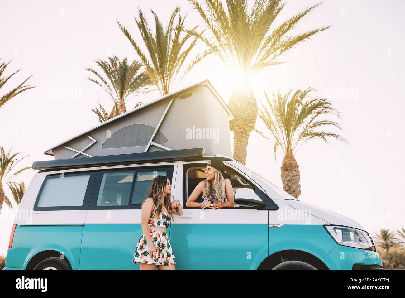 Two young women having fun in her van near the beach Stock Photo - Alamy