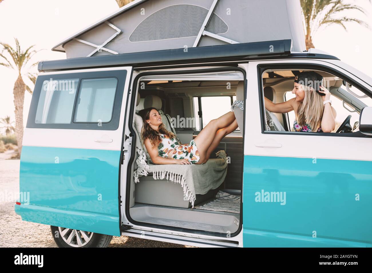 Two young women having fun in her van near the beach Stock Photo - Alamy