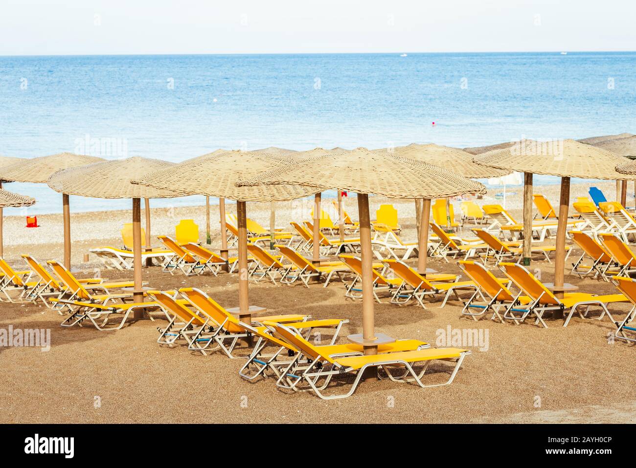 Empty sunbeds and sun umbrellas at sandy beach at seashore Stock Photo ...