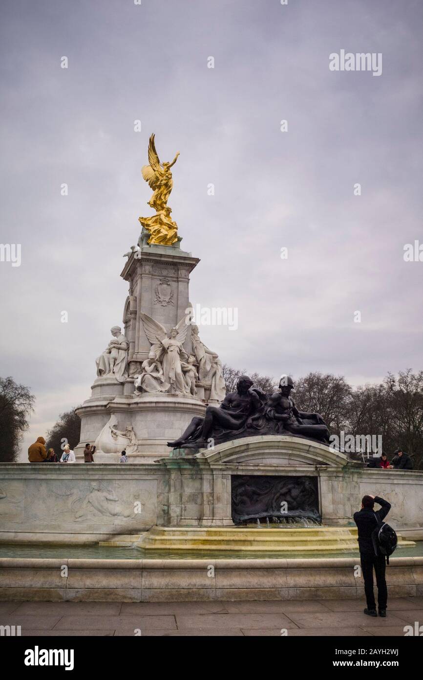 Visitor taking photograph in front of the water feature of the Queen ...