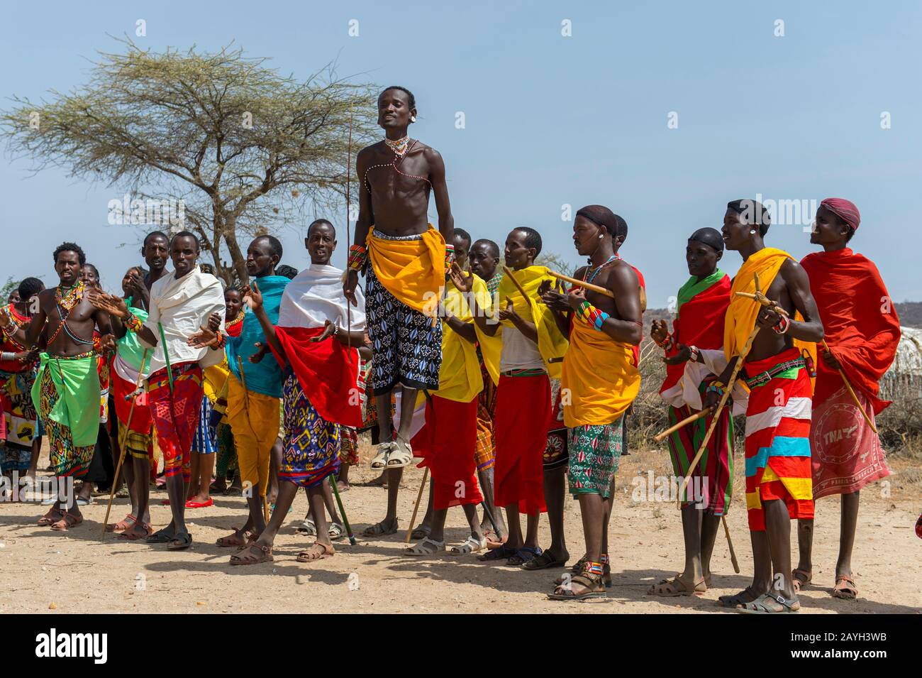A group of young Samburu men dressed in traditional clothing performing ...