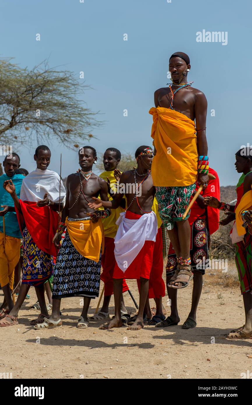 A group of young Samburu men dressed in traditional clothing performing ...