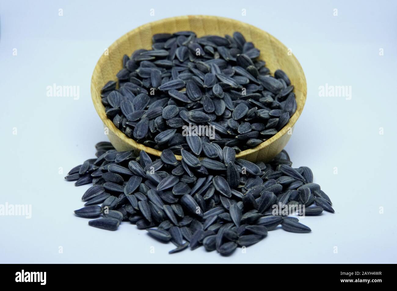 Close up of sunflower seeds spilled from a small wooden plate Stock ...