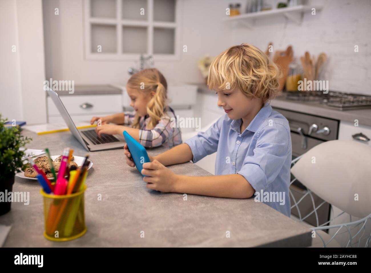 Cute children sitting table hi-res stock photography and images - Alamy