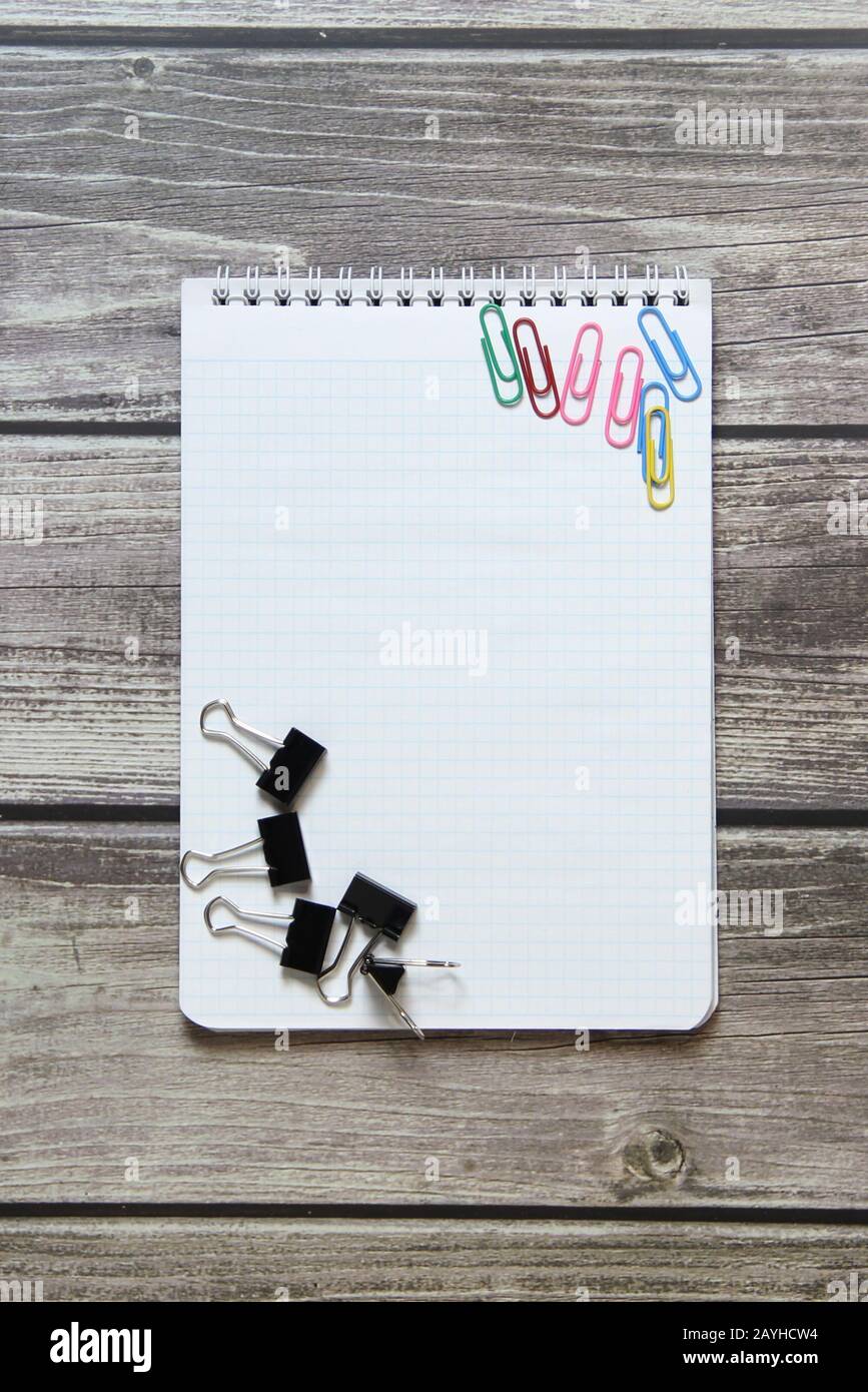 Notepad with a blank white sheet in a checker paper with a clip and ...