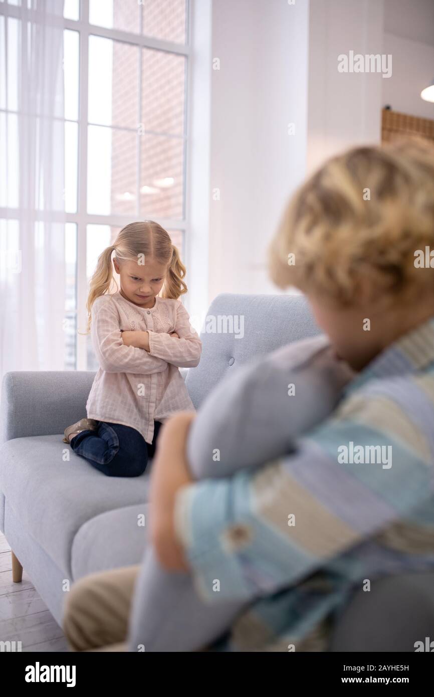 Blond cute girl with ponytails looking offended Stock Photo - Alamy
