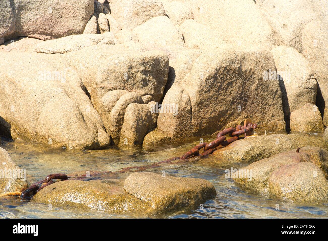 Rusty chain laying at the rocks in water Stock Photo - Alamy