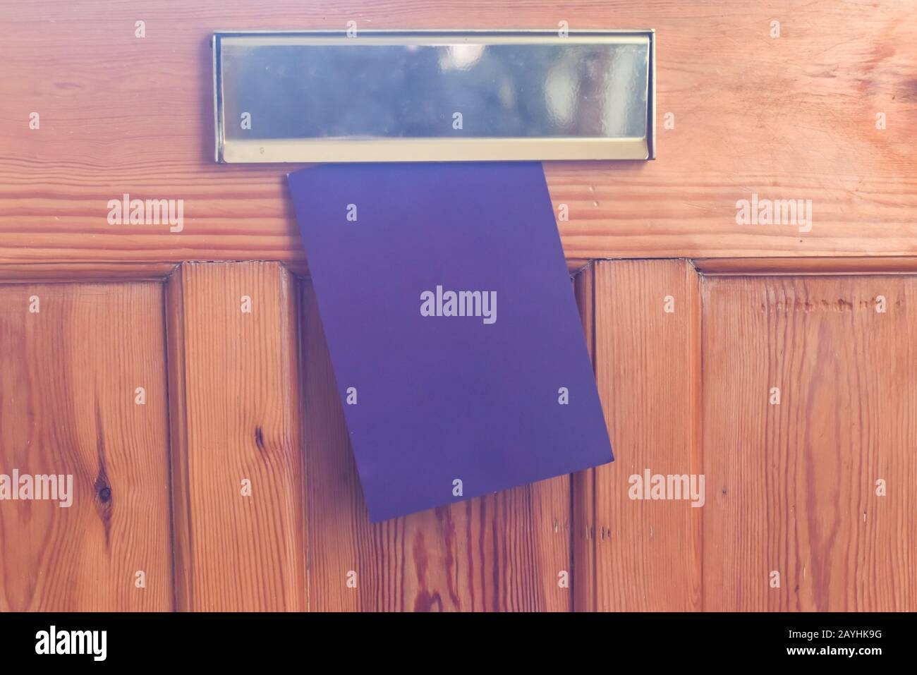 Blank leaflet or flyer being posted through a letter box unwanted junk ...