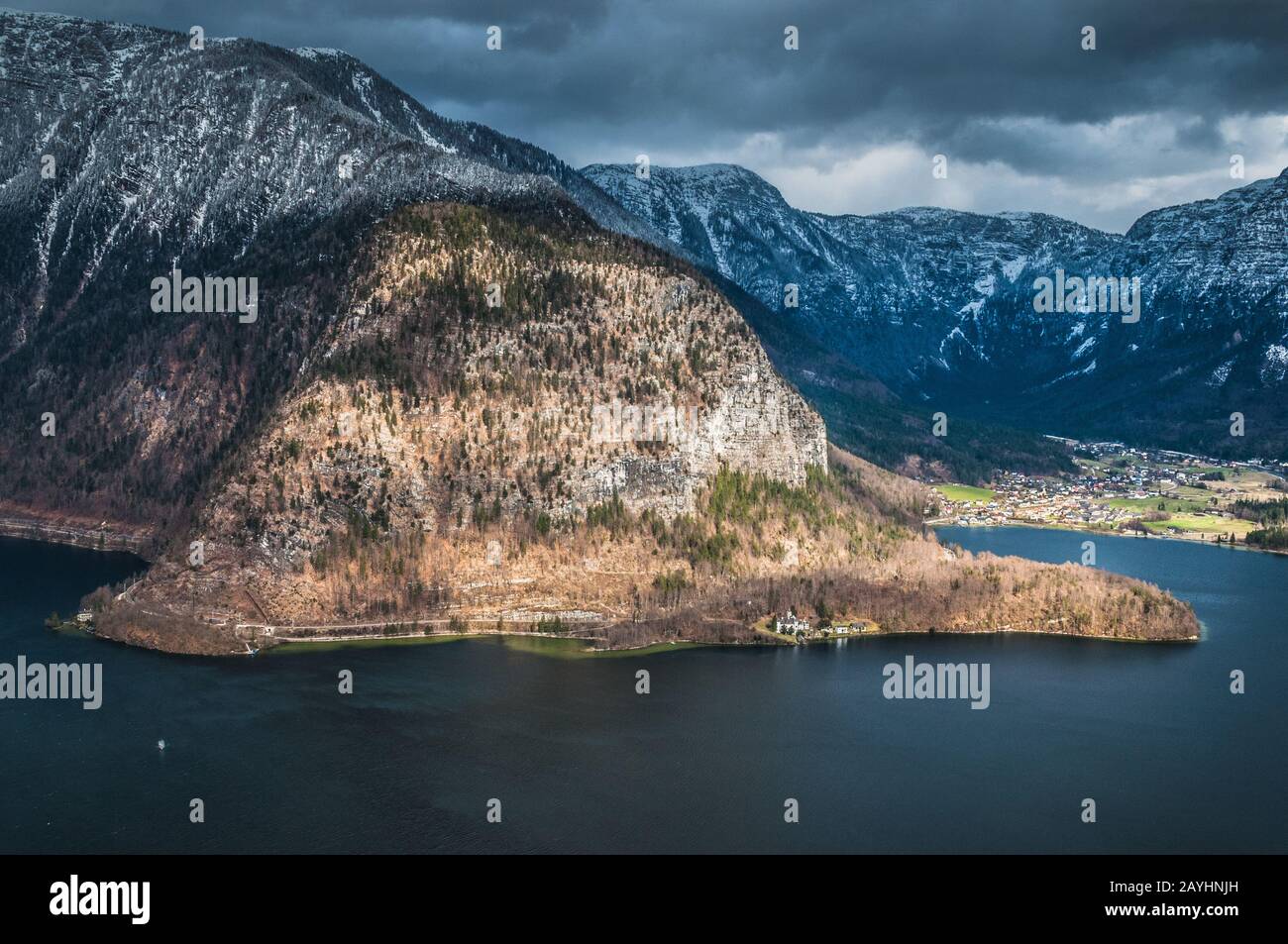 Big calm lake between the mountains covered with snow, under the cloudy ...
