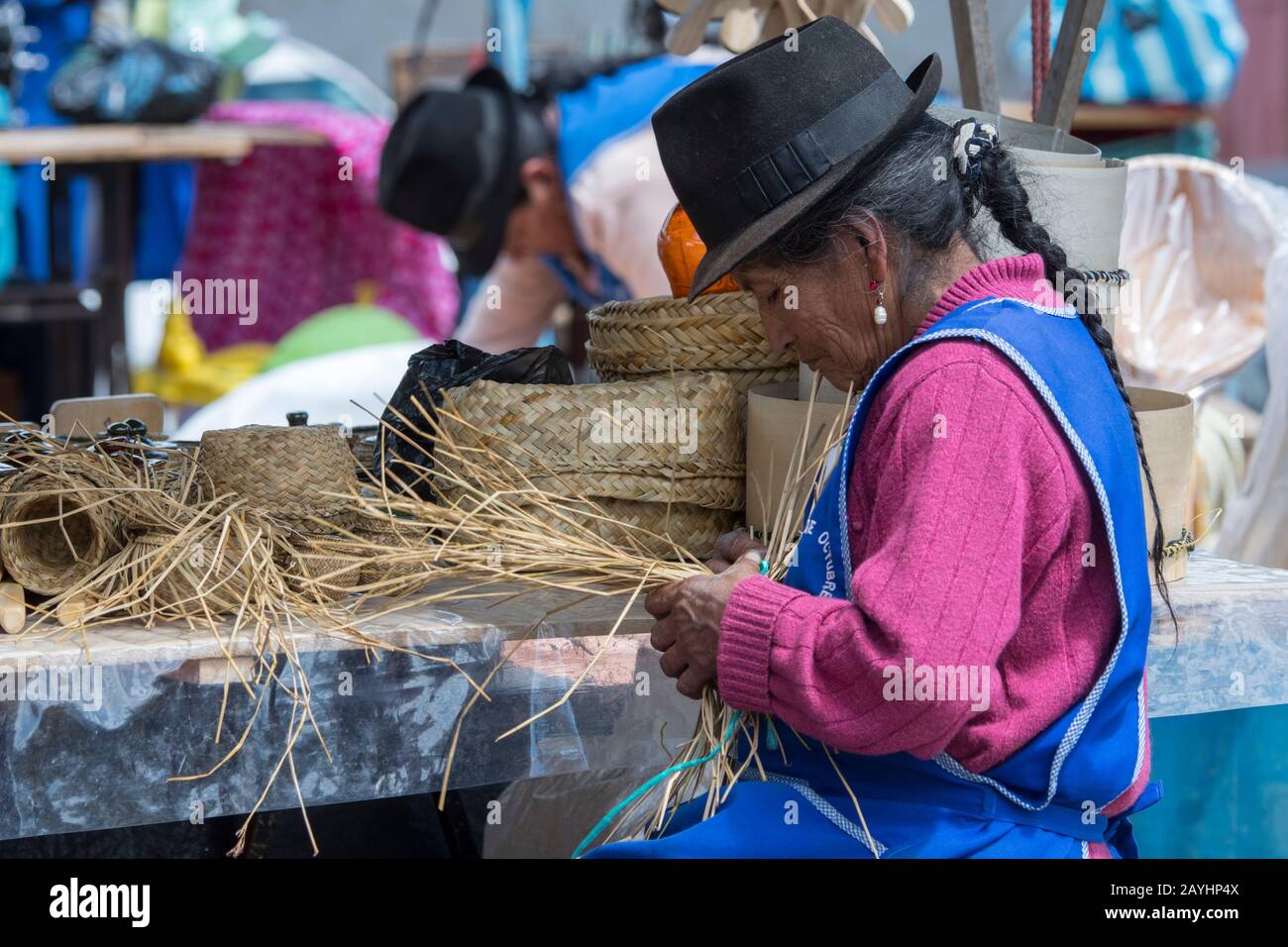 A woman is weaving baskets on the indigenous market of Saquisili in the ...
