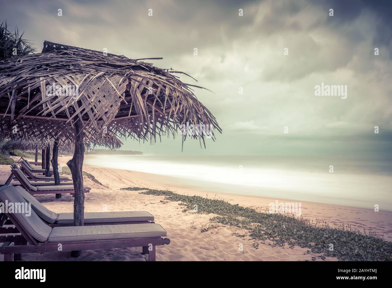Beach beds on the tropical beach. Long exposure for blurred water and ...