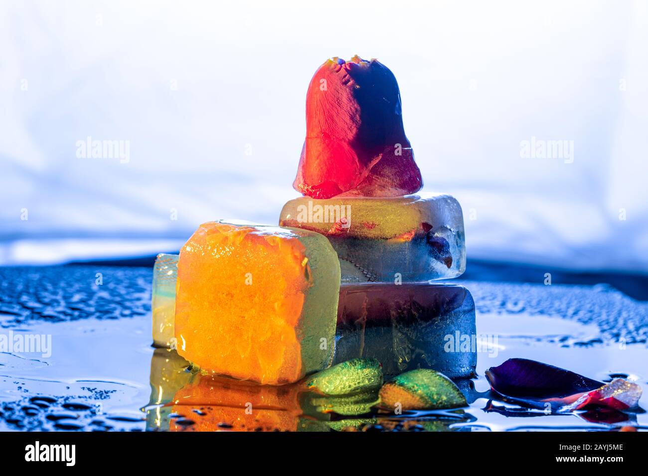 Creative abstract composition of colourful ice cubs on wet table top ...
