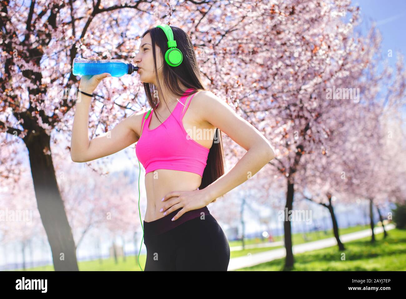 Female runner drinking energy drink during the training. Portrait of ...