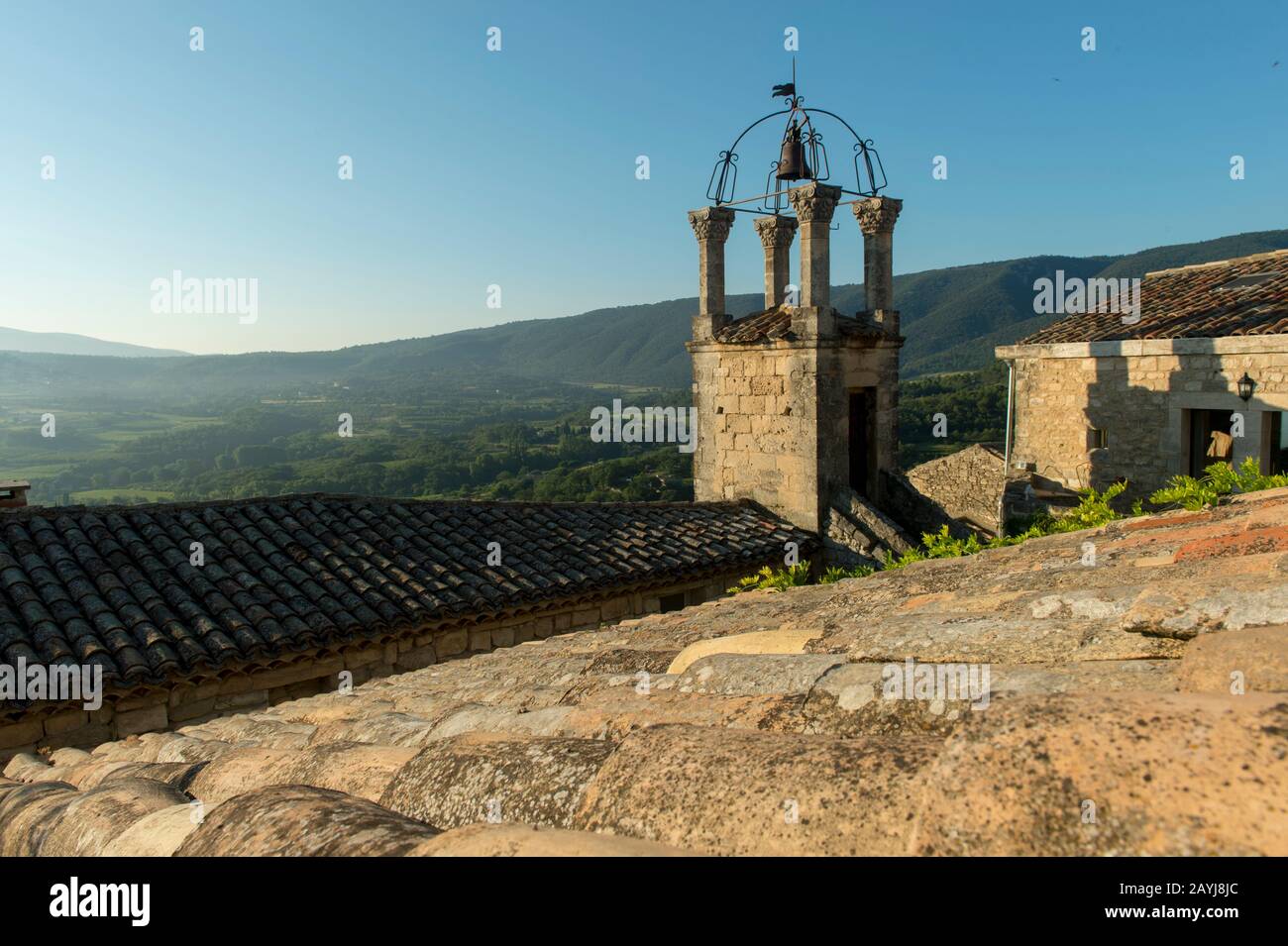 Village scene with a bell tower in the hillside village of Lacoste in ...