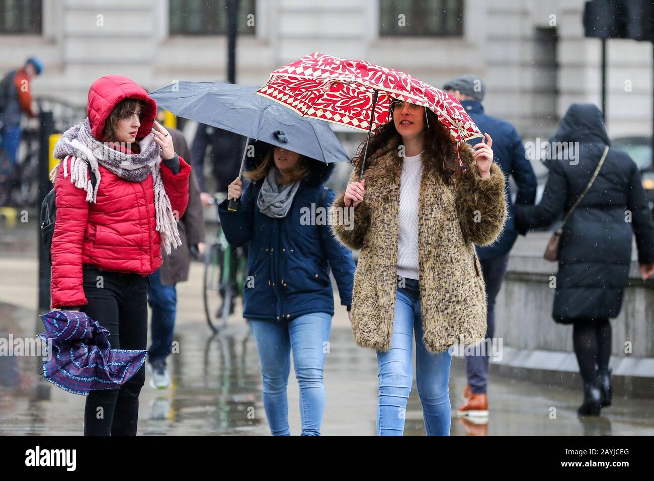 Women struggle with umbrellas in central London during wet and windy ...