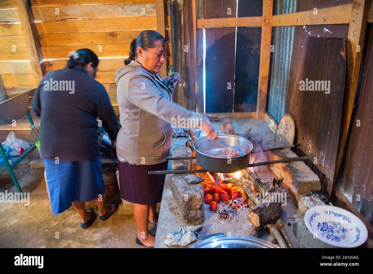 A Woman is cooking eggs in the kitchen of a house of the Mixtec village ...
