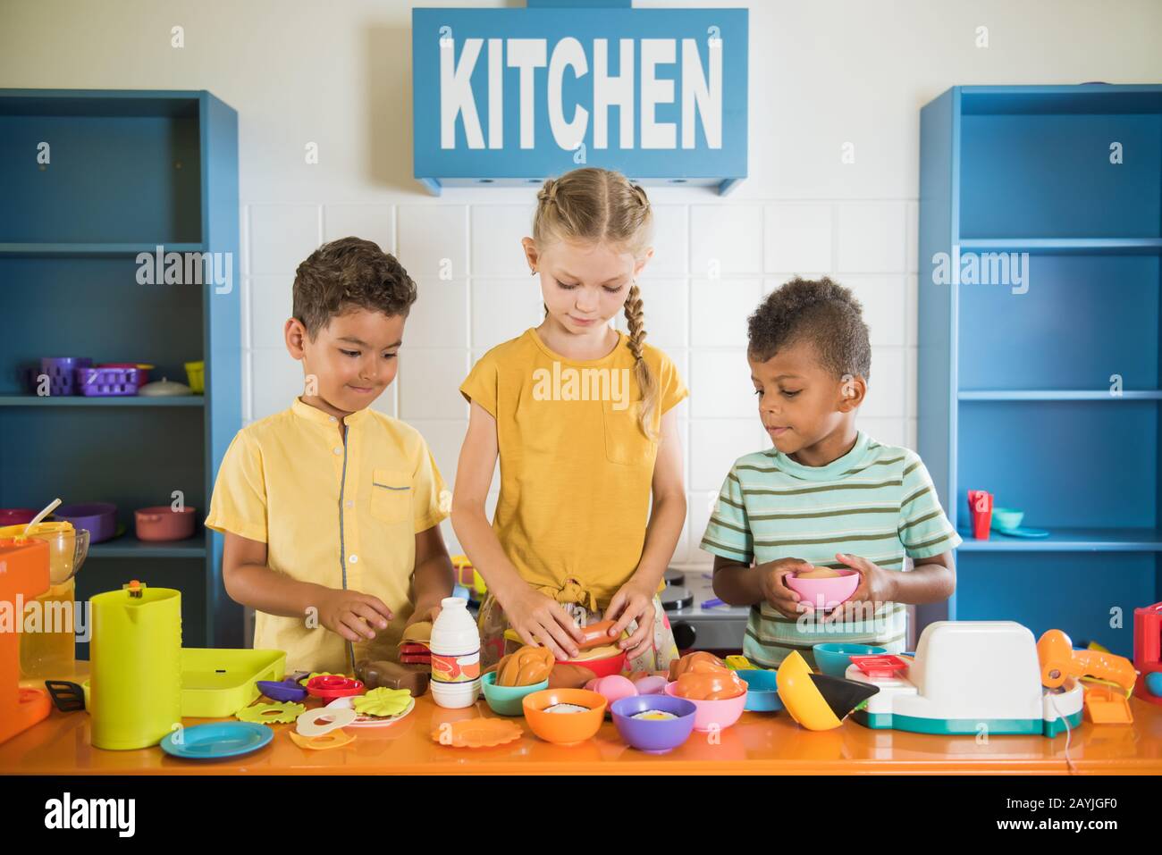 Happy kids playing with plastic tableware Stock Photo - Alamy