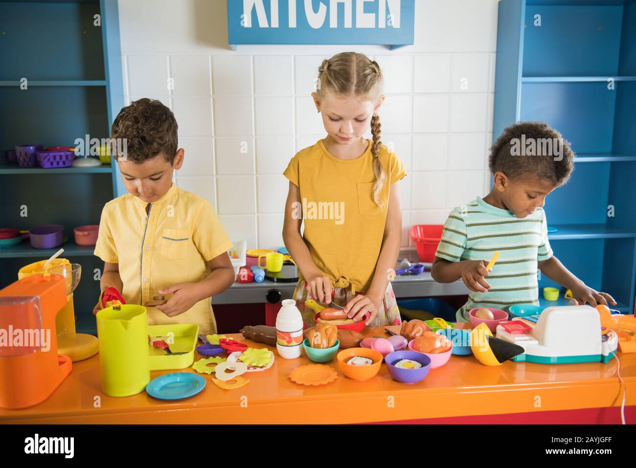 Happy kids playing with a toy kitchen in children room Stock Photo - Alamy