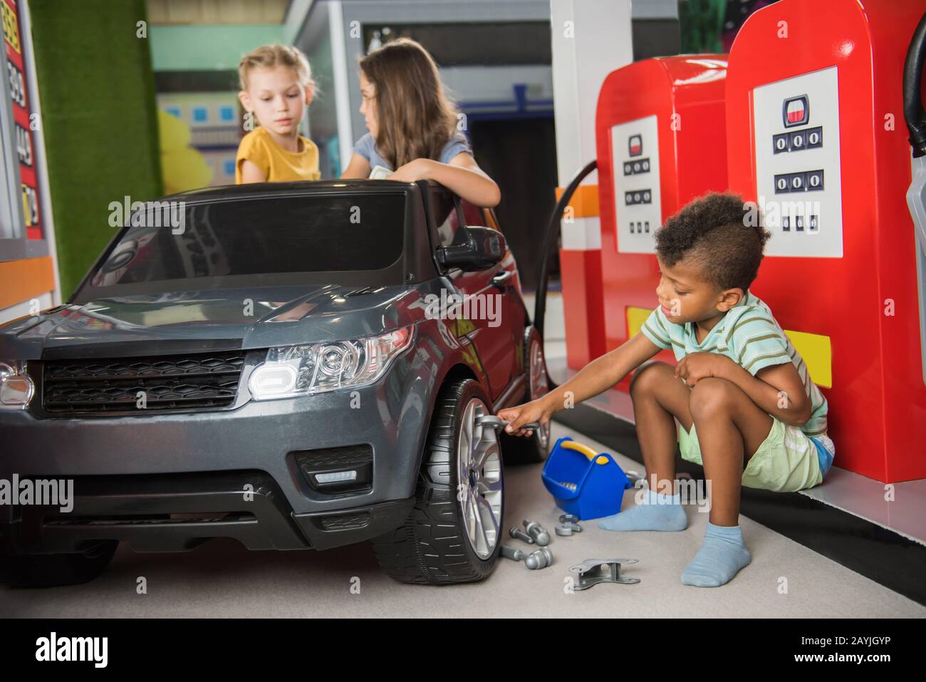 Cute little girls at car service station in playroom Stock Photo - Alamy