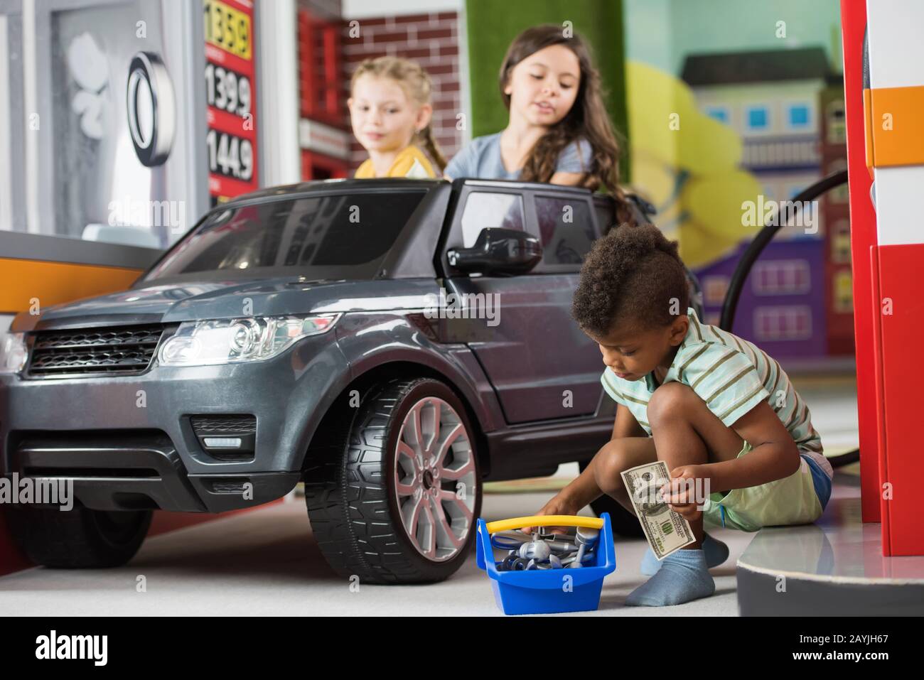 Kids playing car service station in play center Stock Photo - Alamy