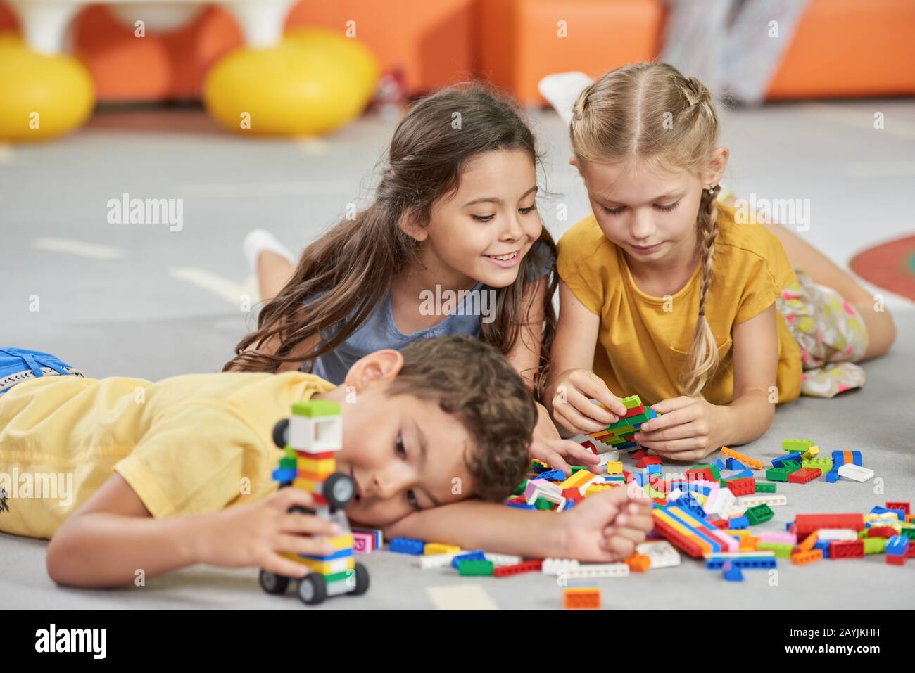 Kids playing with toys on the floor Stock Photo - Alamy