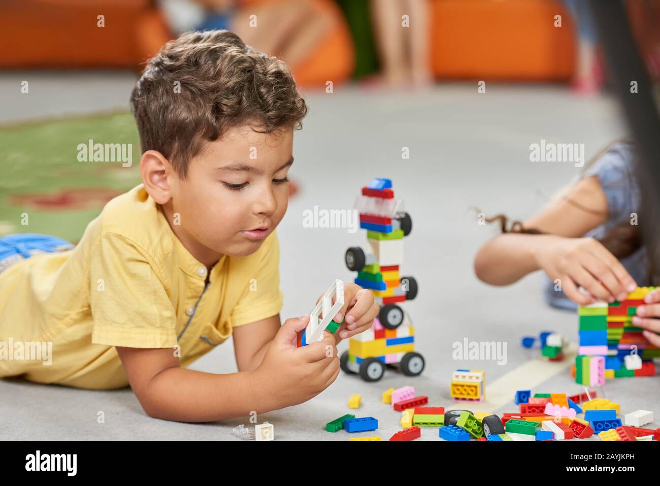 Kids playing with toys on the floor Stock Photo - Alamy
