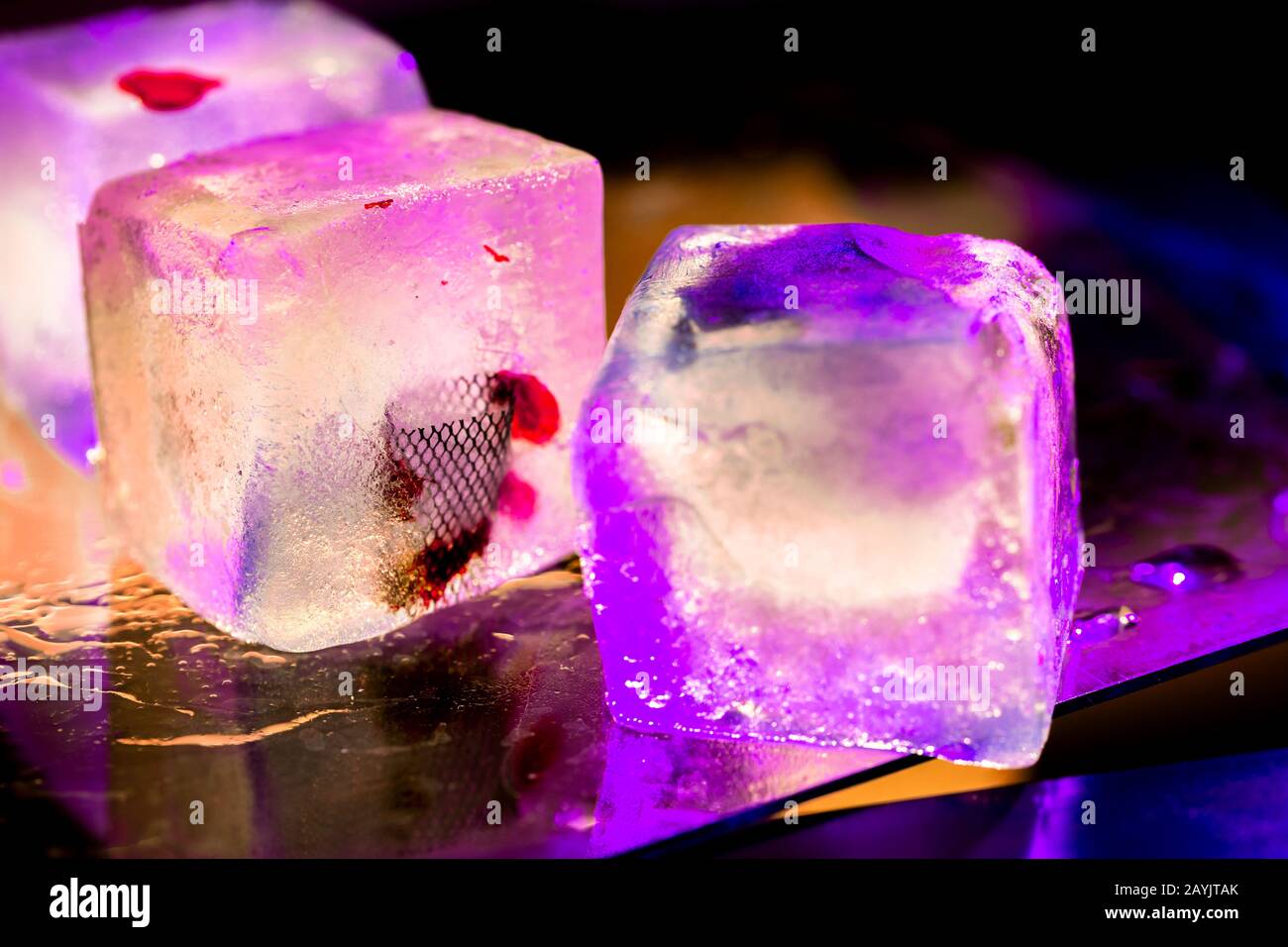 Illuminated ice cubes on glass - creative abstract background in vivid ...
