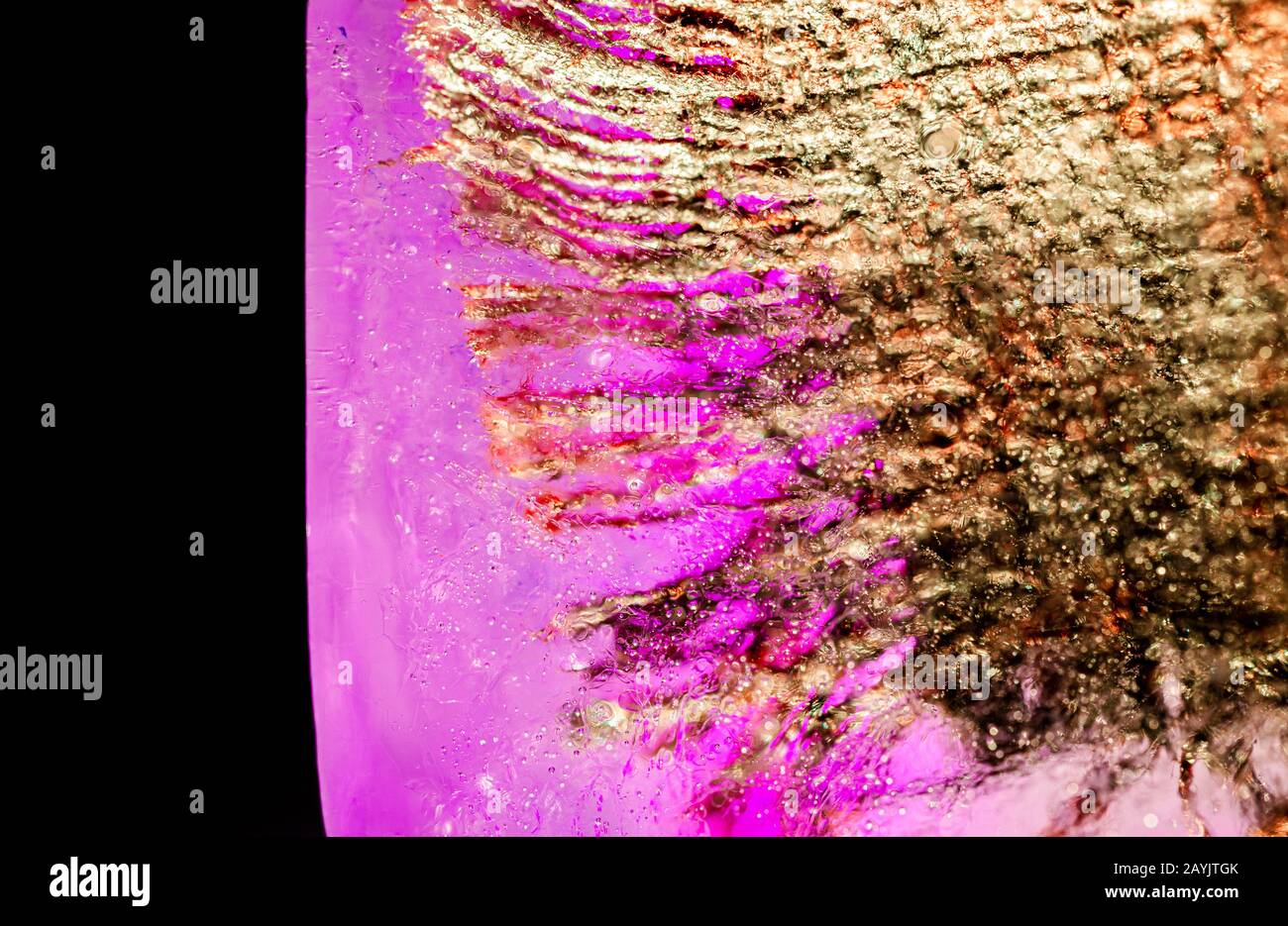 Illuminated ice cube - abstract macro composition in gold and magenta ...