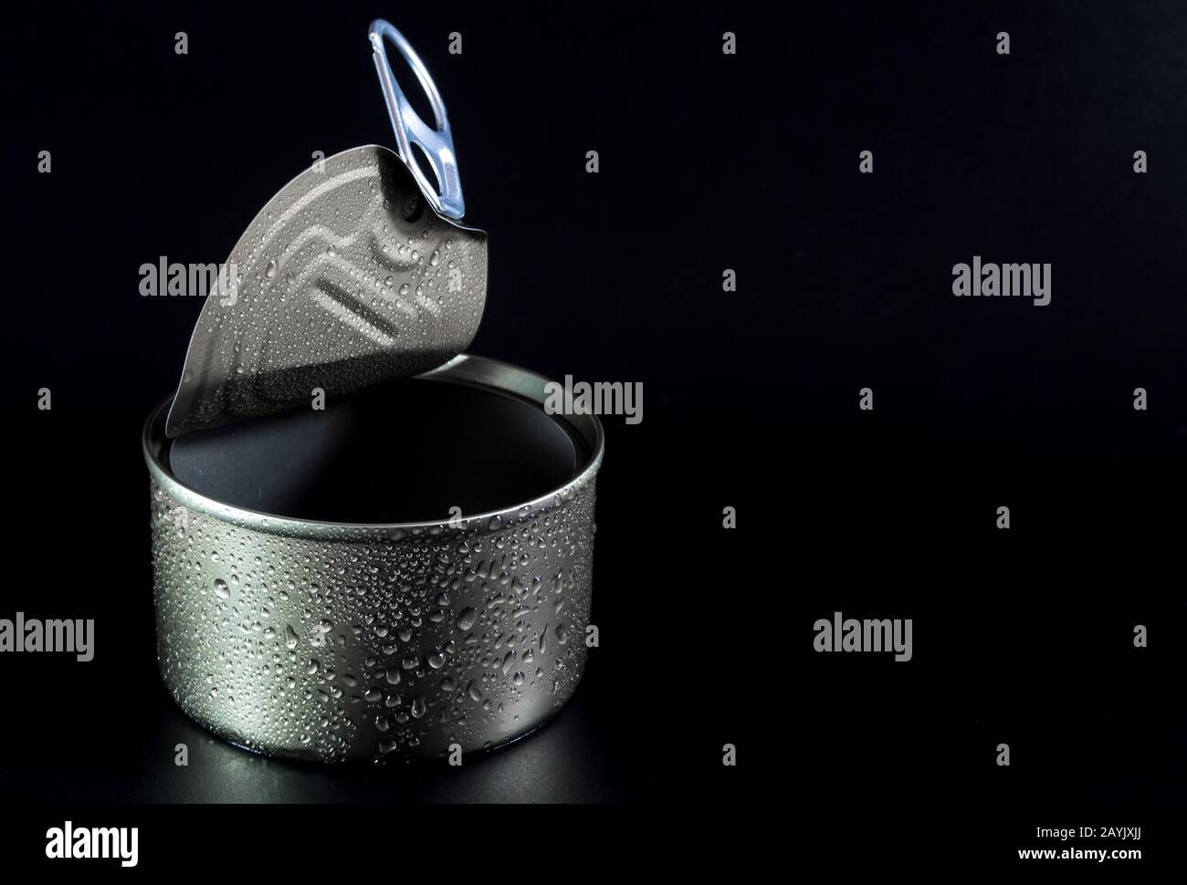 Opened pull cap of empty food can on black background Stock Photo - Alamy