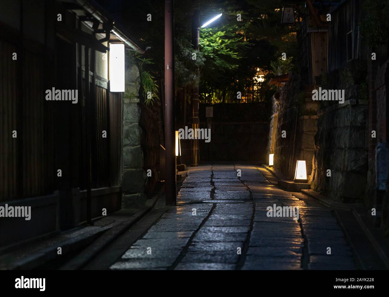 Lamps illuminate quiet alleyway through historic Kyoto neighborhood ...