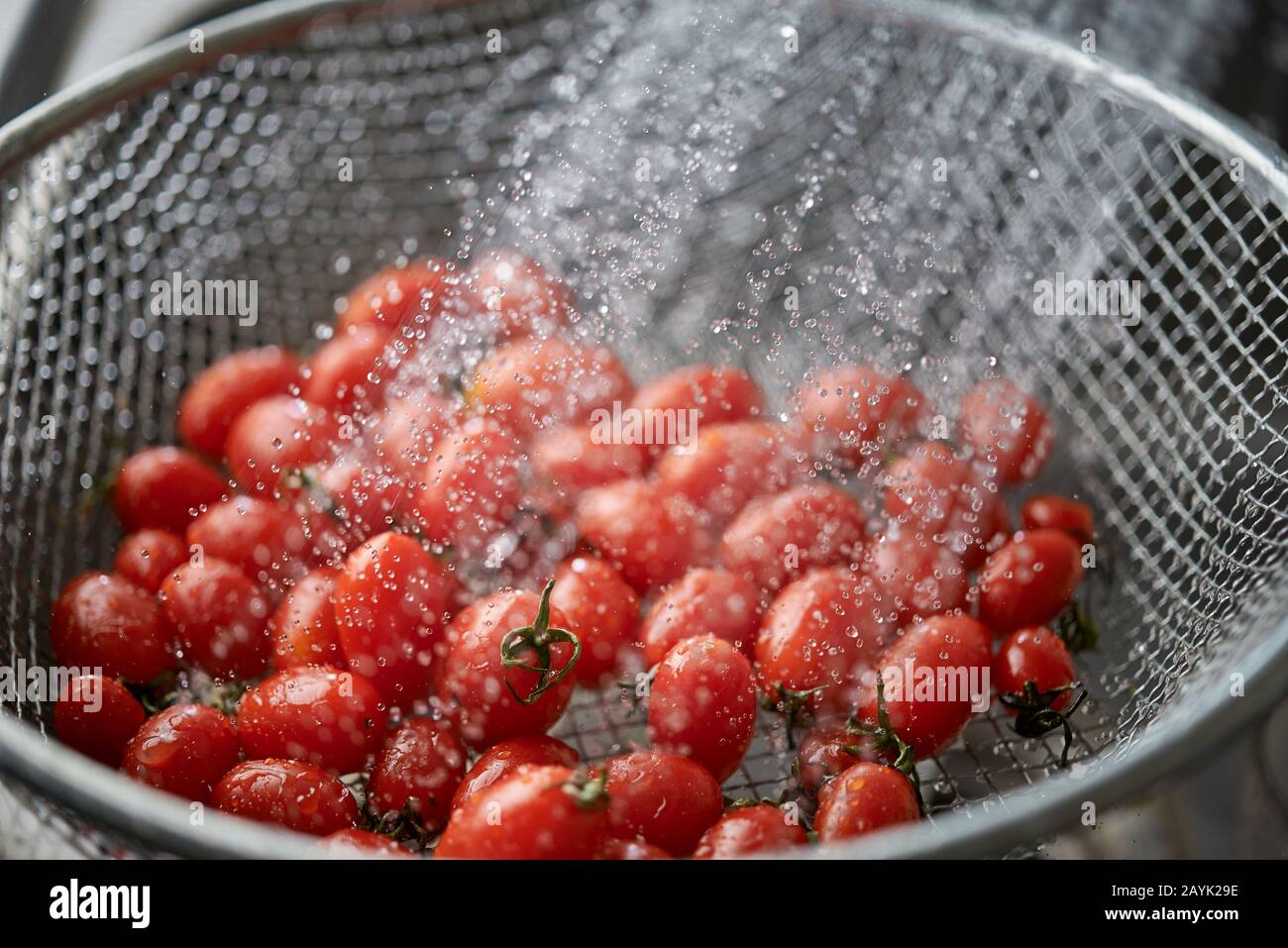 Cleaning the vivid red ripe tomatoes in the metal wire basket Stock ...