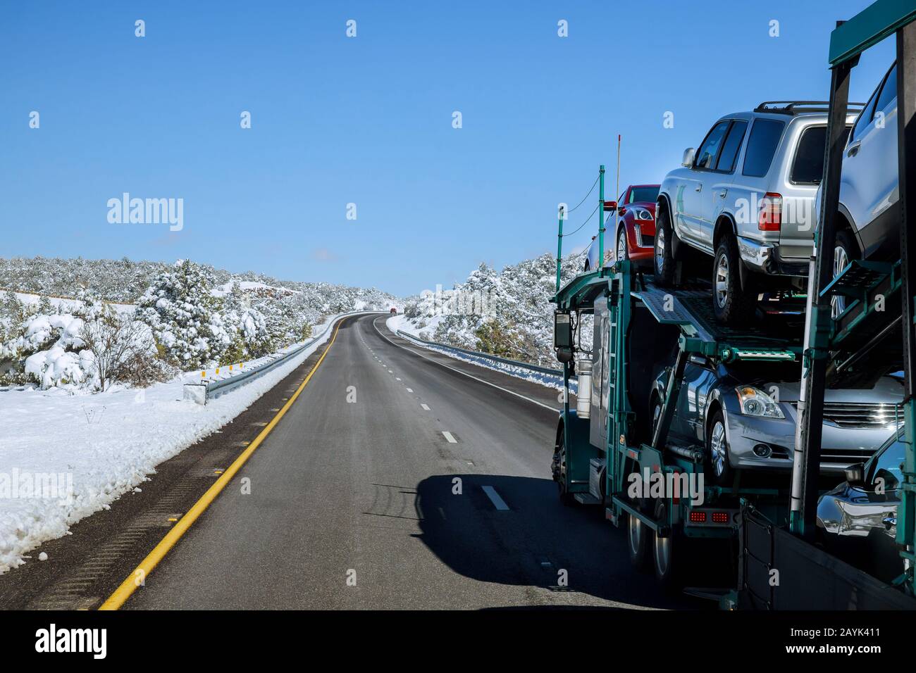 Logistics, transportation of new cars on a two-level of snowy road with ...