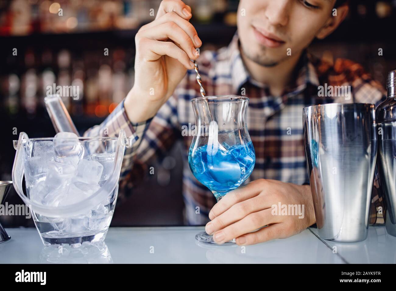 Barman mixes blue cocktail show with colorful alcoholic and smoke bar ...