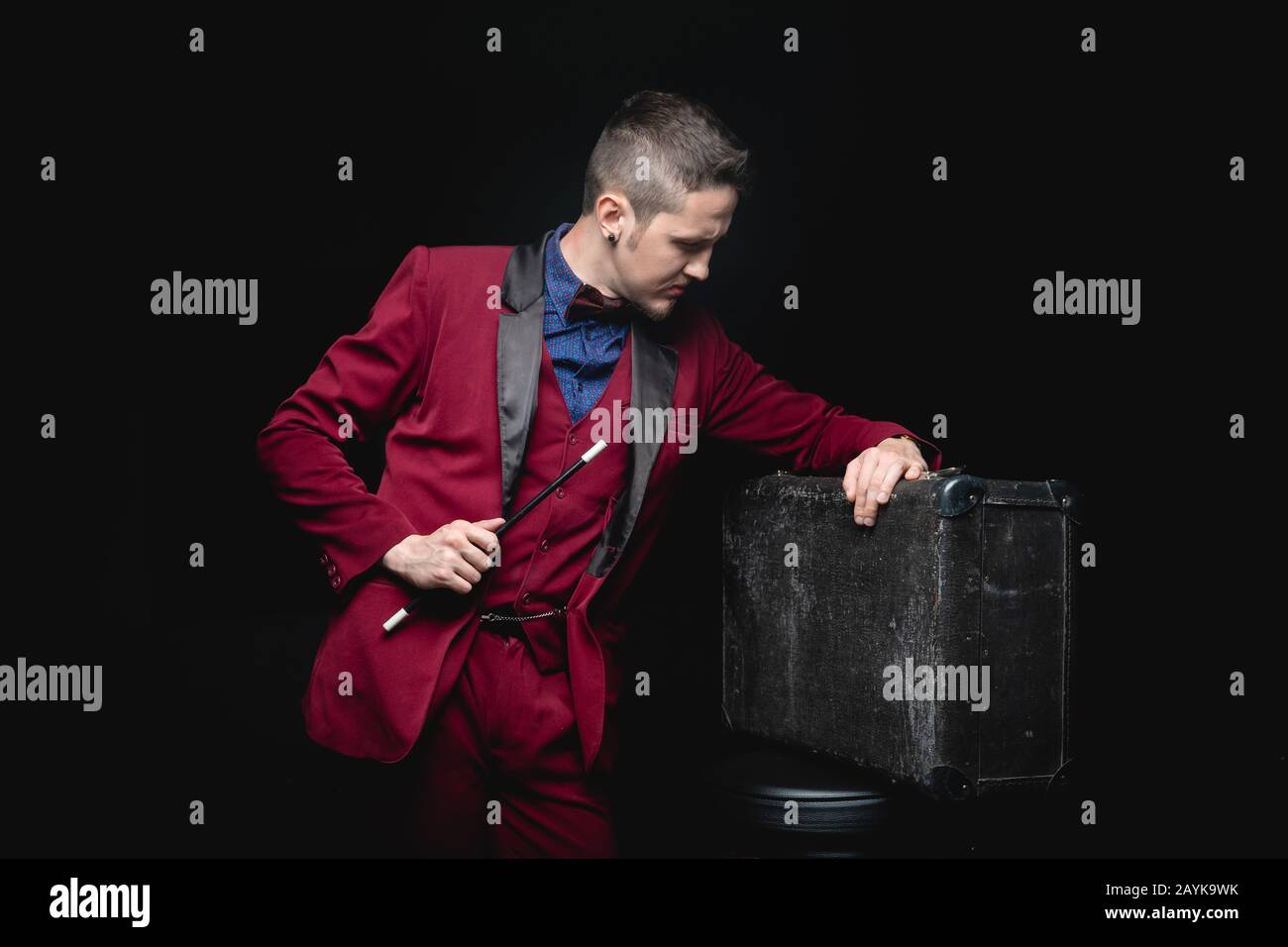 Magician man with magic wand and suitcase on black background Stock ...