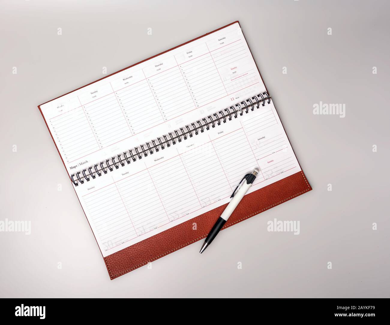 Closed notebook in leather binding with pen on a gray background. Place ...