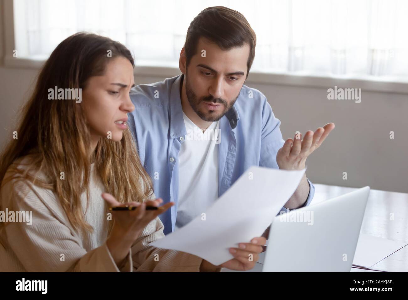 Frustrated married couple confused by paperwork from bank Stock Photo ...