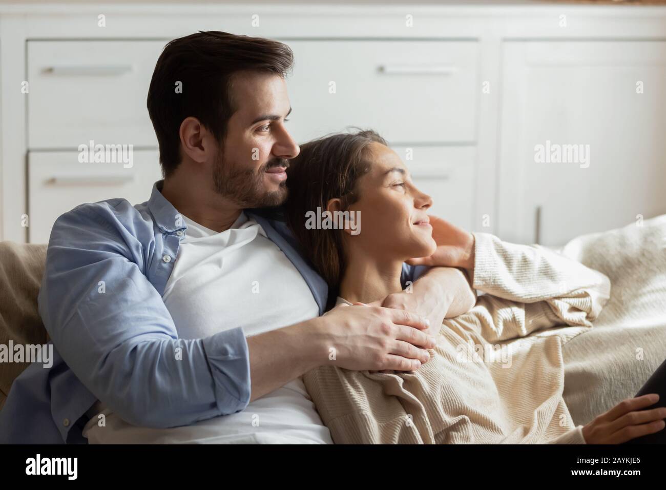Happy couple relax cuddle at home dreaming Stock Photo - Alamy