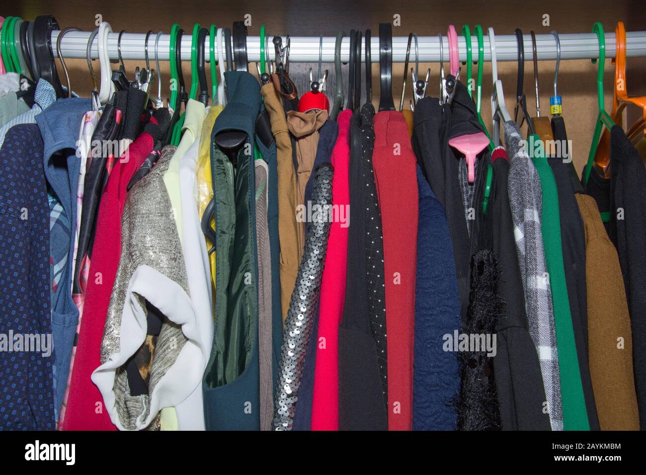 Wardrobe with clothes hanging on different colored hangers. Colorful ...