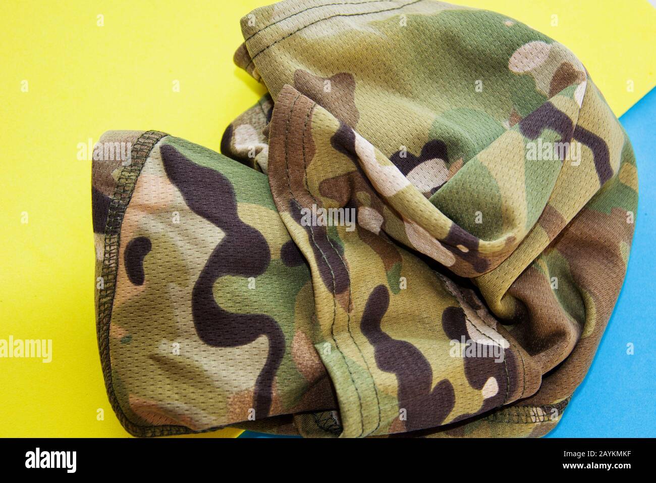 Camo balaclava mask on yellow and blue background Stock Photo - Alamy