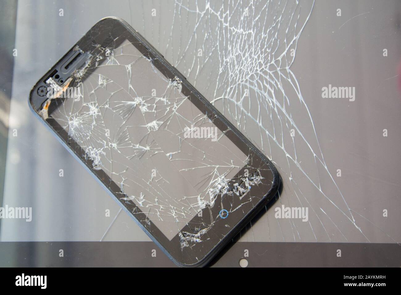 A smartphone with a broken screen and a tablet computer with a broken ...