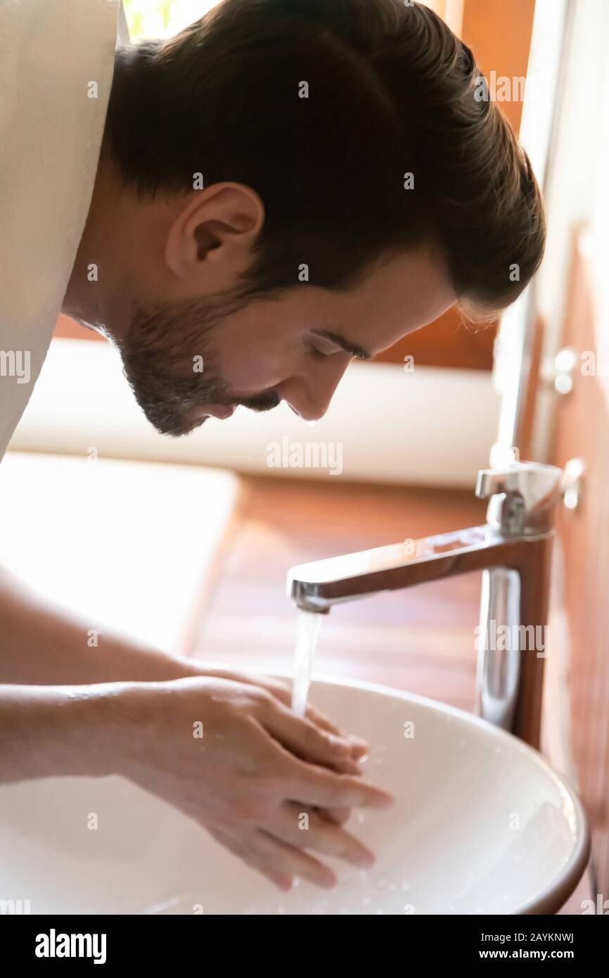 Caucasian man wash face do morning routine in bathroom Stock Photo - Alamy
