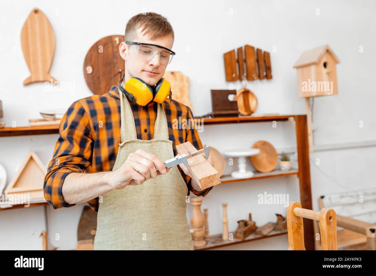 male carpenter measuring a wooden workpiece with a caliper Stock Photo ...