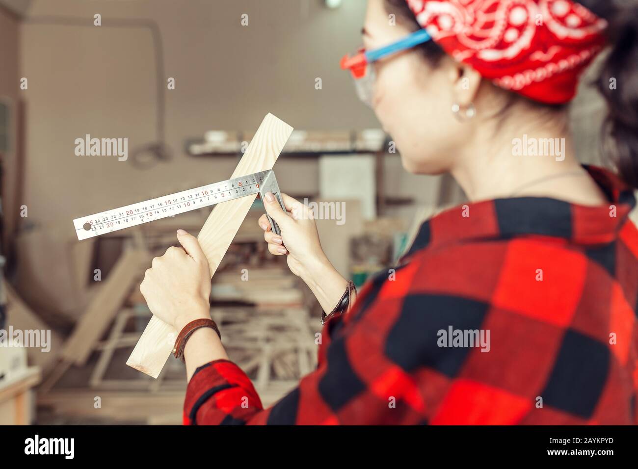 Woman professional works with wood and measures it with a ruler corner ...