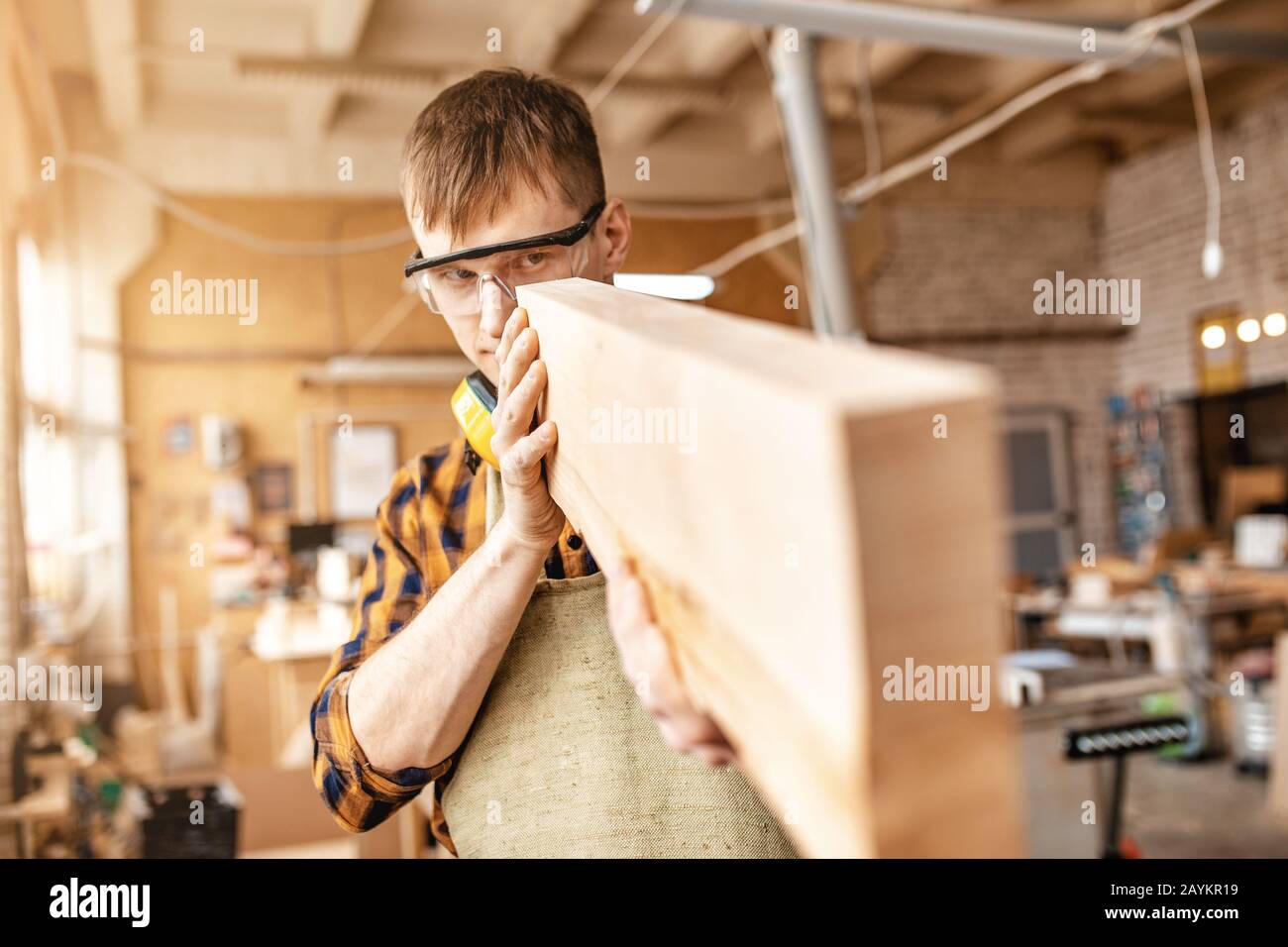 Man carpenter working with wooden workpieces at the construction site ...